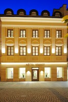 Fachada de hotel com estilo arquitetônico clássico, destacando janelas em arco e uma entrada central.