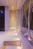 Um interior moderno com design minimalista, apresentando um corredor comprido e estreito com uma série de degraus que levam a uma área de estar.