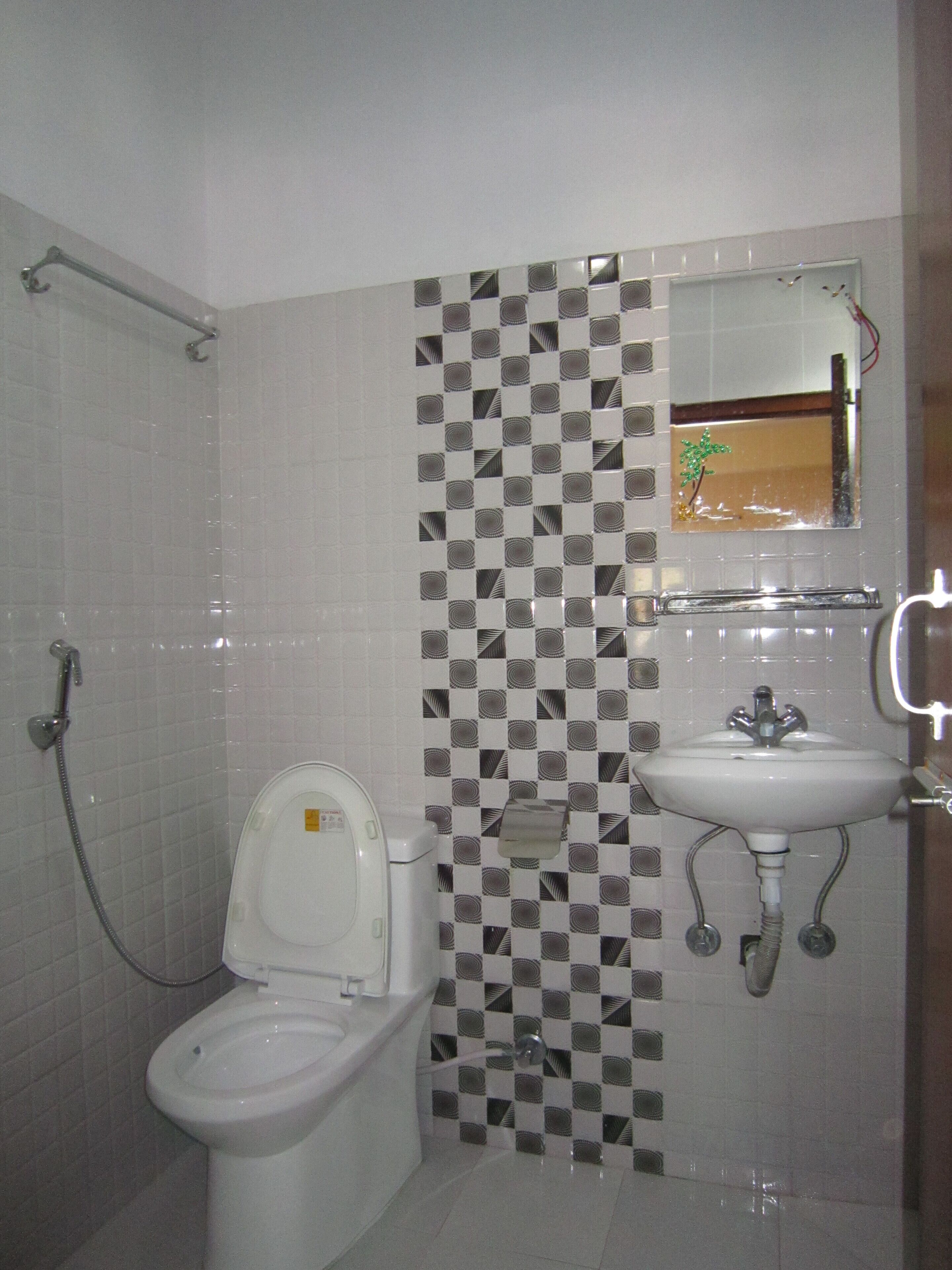 Casa de banho com sanita, lavatório e chuveiro.