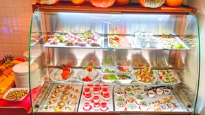 Um buffet com diversos alimentos e utensílios.