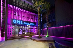 Exterior do Hotel One Fukun com fachada moderna e sinalização iluminada.