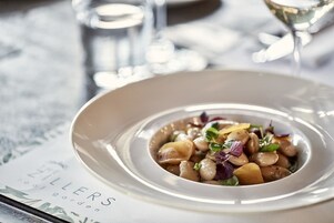 Uma tigela de comida sobre uma mesa, com um menu ao fundo.