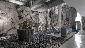 Um espaço moderno com parede de pedra, área de estar e planta em vaso.