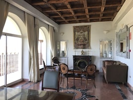 Um quarto espaçoso com teto alto, lareira e um espelho grande.