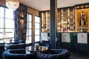 Uma área de bar com uma estátua de Buda, banquetas e diversas garrafas.