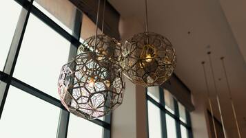 Um interior moderno com luminárias pendentes geométricas e grandes janelas.