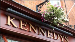 Um edifício com o nome 'KENNEDYS' em letras grandes na fachada.