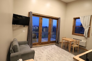 Chalé Deluxe, 1 cama king-size, acessível, vista para o lago | Sala de estar | Televisor LED