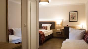 Quarto de hotel com cama, mesa de cabeceira, abajur e uma moldura na parede.