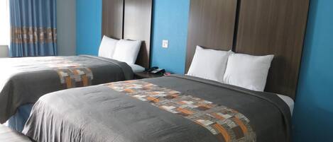 Quarto de hotel com duas camas, cada uma com cabeceira, telefone e mesa de cabeceira.