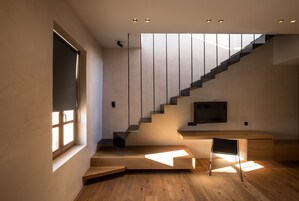 Um interior moderno com escada, soalho de madeira e um espaço de trabalho.