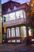 Um edifício de dois andares com varanda e janelas amplas.