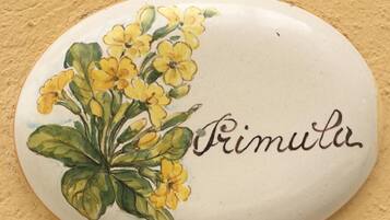 Uma pedra branca com flores amarelas e a palavra "Rimula" escrita nela.