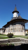 Um edifício histórico com uma torre central e uma cúpula, apresentando frescos elaborados e fachada de pedra.