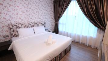 Cama bem arrumada com saia listrada, papel de parede floral e janela com cortinas.