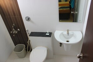 Uma casa de banho com sanita, lavatório e chuveiro.