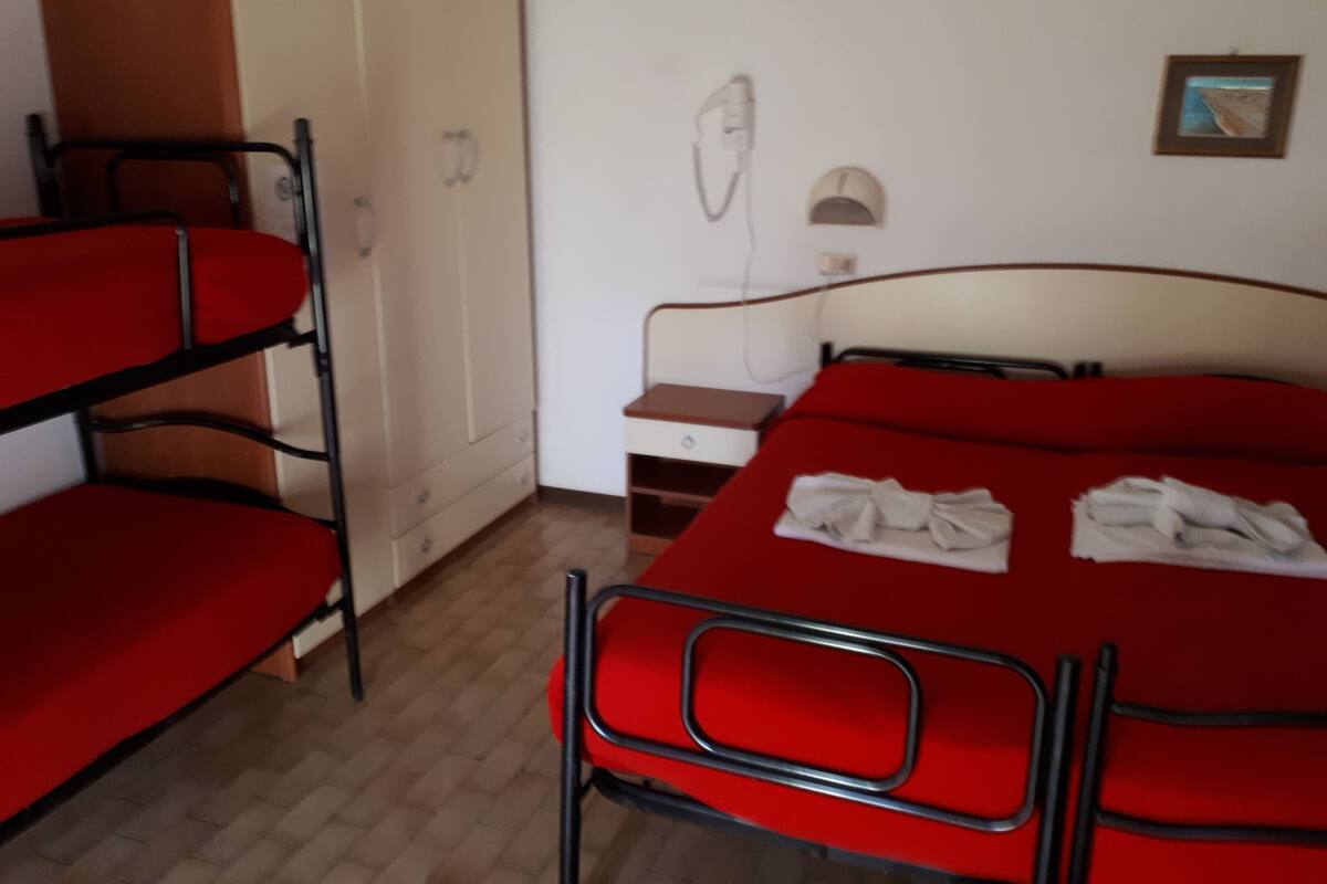 Quarto com beliches, uma escrivaninha e uma cadeira.