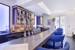 Uma área de bar com balcão extenso, diversas torneiras e um cardápio.