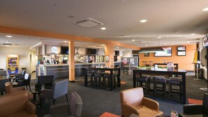Um saguão de hotel com áreas de estar, um bar e um restaurante.