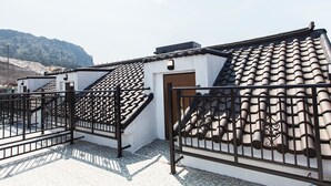 Um edifício tradicional com telhado de telhas e um pátio murado.