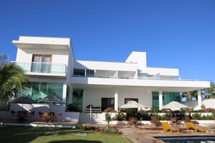 Uma casa moderna de dois andares com varanda, área de estar externa e piscina.
