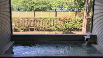 Quarto com vista para um jardim, uma piscina pequena e um cercado de madeira.