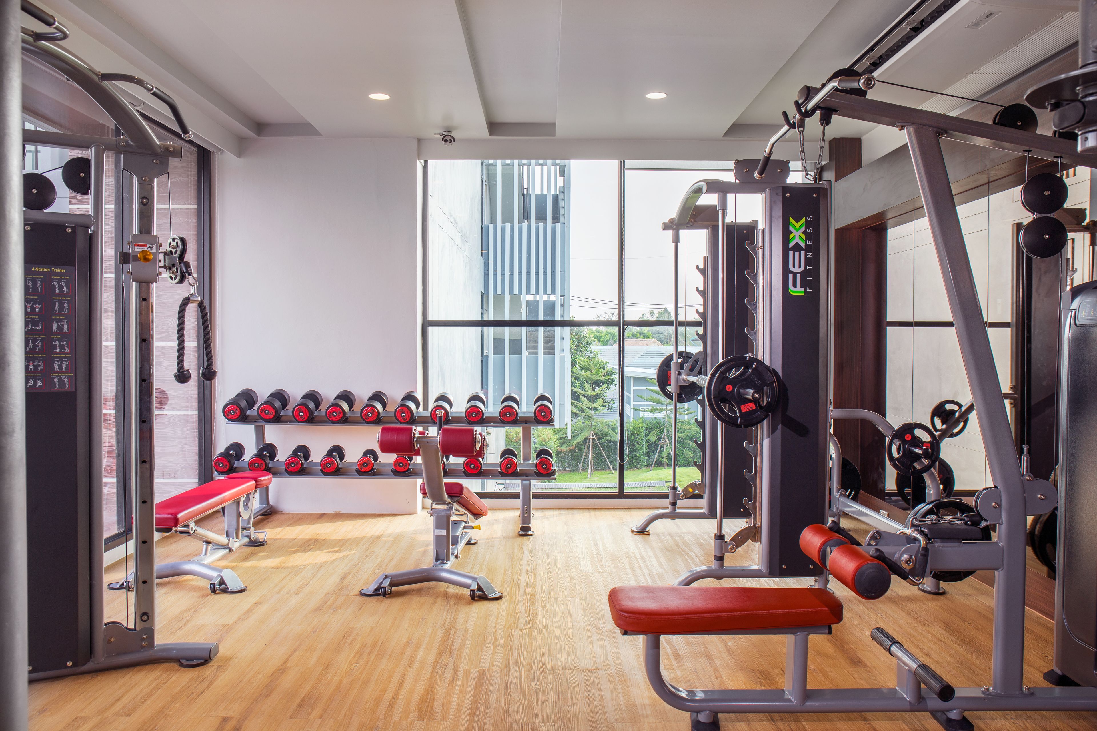 Uma academia com equipamentos de musculação, bancos e halteres.
