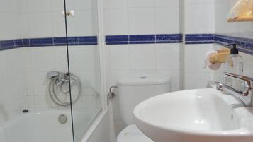 Uma casa de banho com banheira, sanita e lavatório.