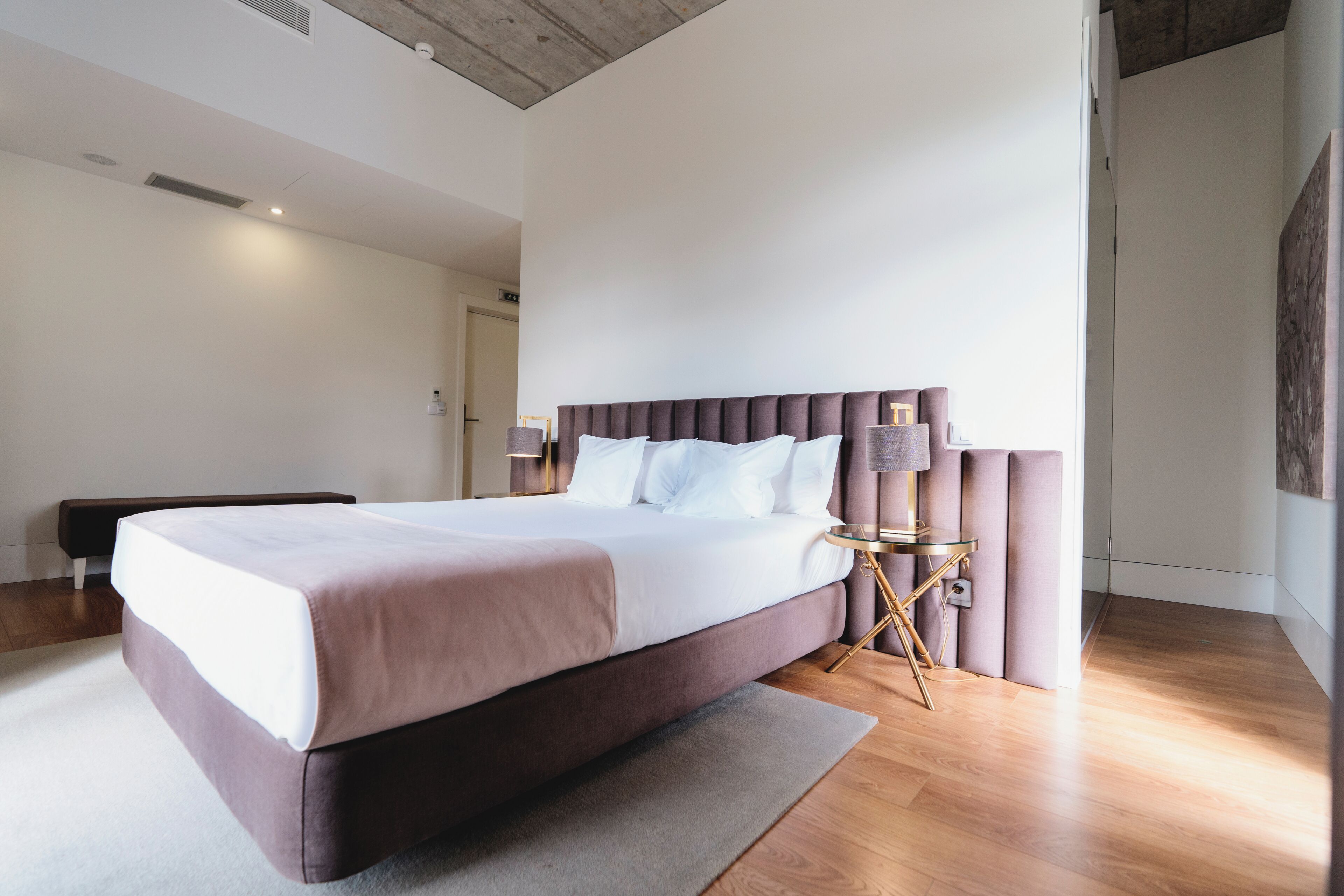 Um quarto moderno com uma cama grande, uma mesa de cabeceira e um criado-mudo.