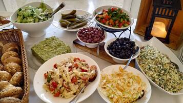 Uma mesa com diversos pratos, incluindo massa, saladas e pão.