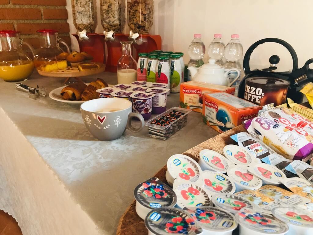 Um buffet de café da manhã com diversos itens, incluindo pães, iogurte e sucos.