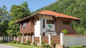 Um edifício de dois andares com um logotipo em forma de 'V' e o nome 'Vitoria' na fachada.