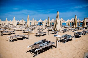 Uma praia privada, espreguiçadeiras, guarda-sóis de praia, mergulho 