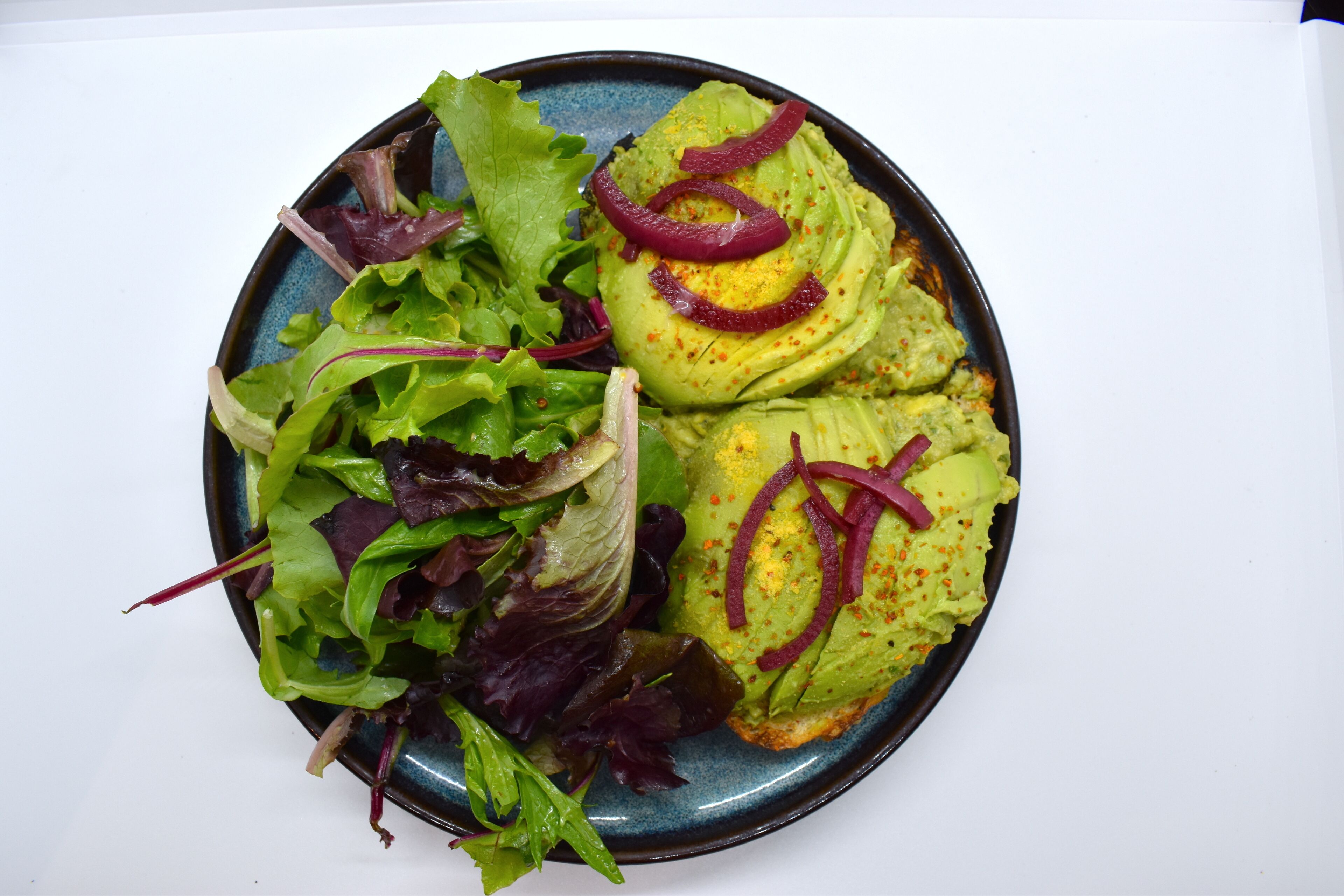 Um prato com salada e fatias de abacate.