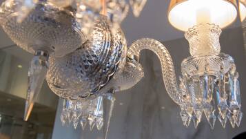 Um candelabro com detalhes complexos em cristal e uma fonte de luz.