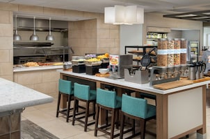 Cozinha moderna com um sistema de buffet, incluindo diversas opções de comida e um espaço para café.