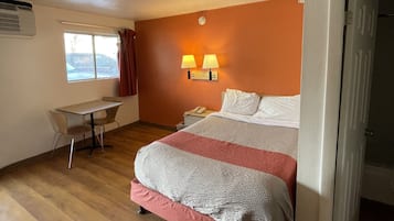 Quarto com cama, abajures, escrivaninha e janela.
