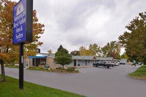 Um estacionamento com um edifício identificado como 'Americas Best Value Inn & Suites' by Wyndham.