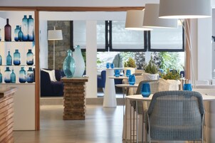 Decoração moderna com área de refeições, incluindo mesa, cadeiras e copos de vidro azul.