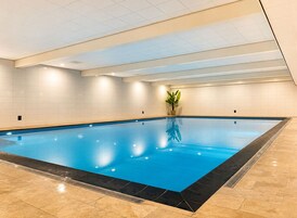 Uma grande piscina coberta com paredes e piso revestidos em azulejo.