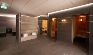 Uma casa de banho moderna com área de chuveiro, zona de estar com mesa e sinal de saída visível.
