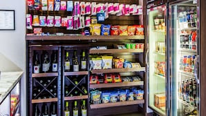 Uma área de máquinas de venda automática com lanches, bebidas e garrafas de vinho.