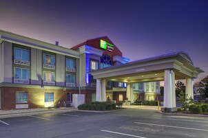 Um hotel Holiday Inn Express & Suites com entrada coberta e estacionamento.
