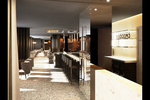 Um hall de hotel moderno com um balcão de recepção extenso, área de bar e assentos.