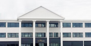 Um edifício moderno com entrada destacada, exibindo uma placa com o nome HOWARD.