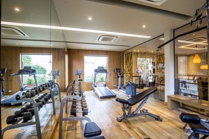Academia moderna com esteiras, halteres e aparelhos de musculação.