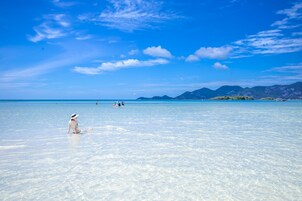 Na praia, praia de areia branca, guarda-sóis de praia