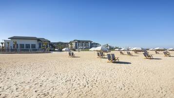 Na praia, areia branca, toalhas de praia