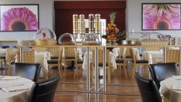Uma sala de jantar com uma mesa longa, cadeiras e um serviço de buffet.