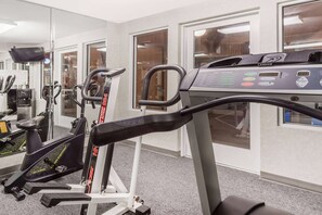 Uma academia com bicicletas ergométricas, esteiras e equipamentos de ginástica.